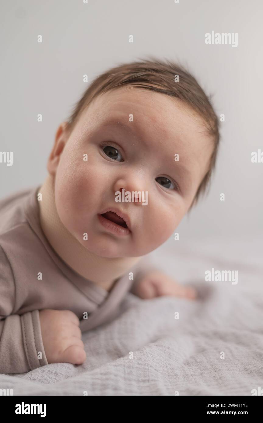 Portrait of a newborn baby lying on his stomach in an orthopedic collar ...
