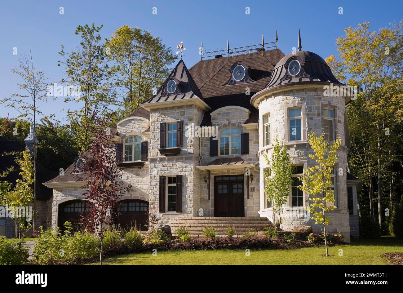 Luxurious two story tan and brown cut stone home with two car garage ...