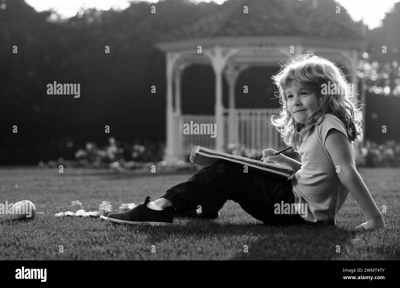 Kid draws in park having fun on nature background. Children creative ...