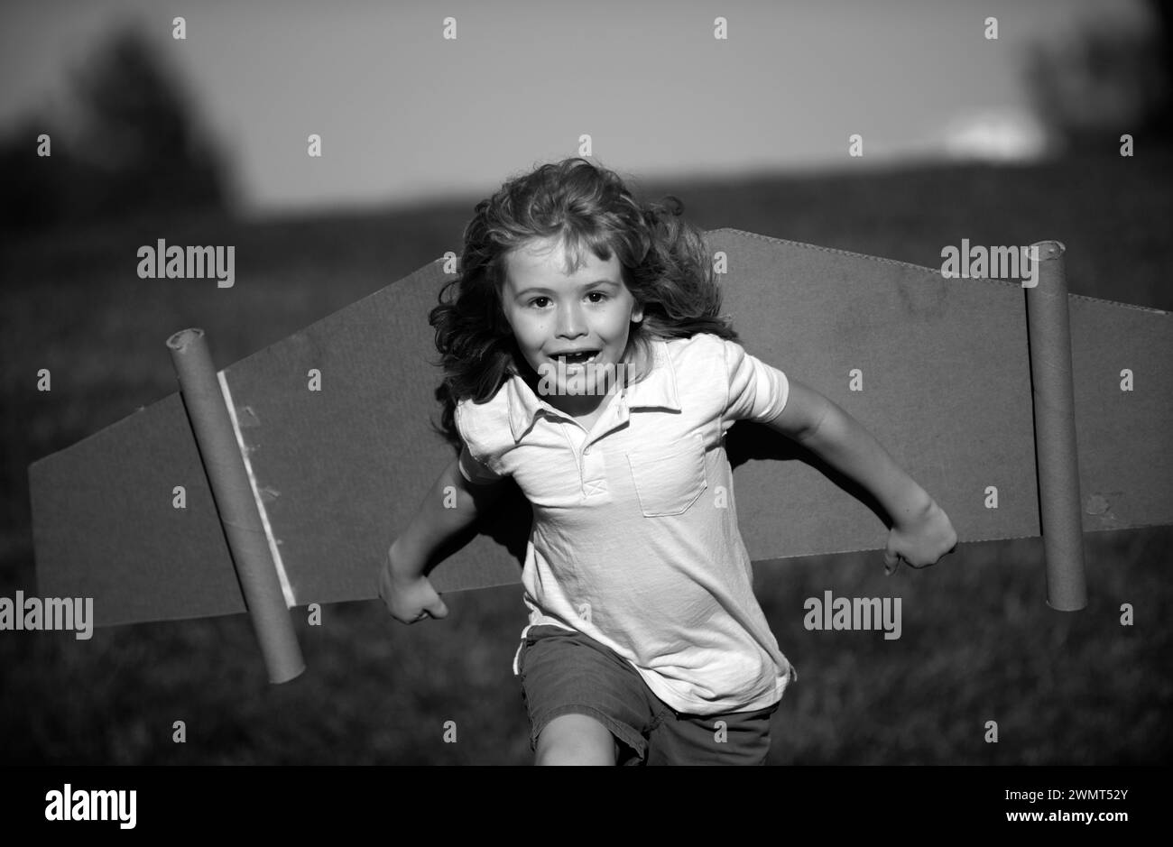 Child boy playing with plane wings outdoors. Cute boy playing pilot and ...