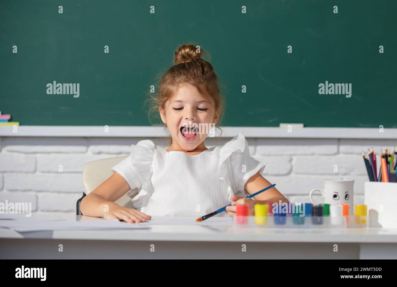 Cute little girl child painting with paints color and brush. Painting ...