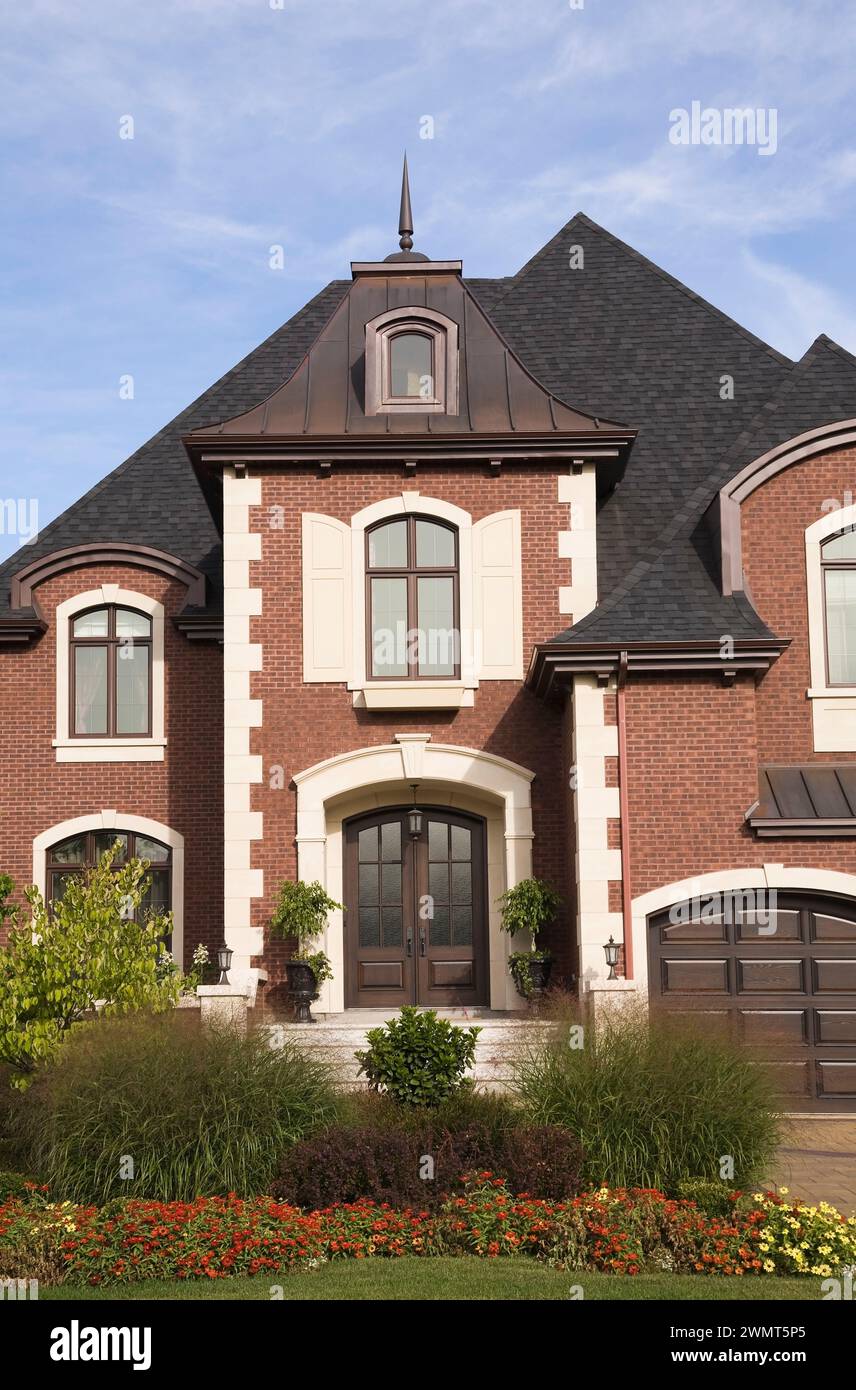 Partial view of luxurious two story red brick home with landscaped ...