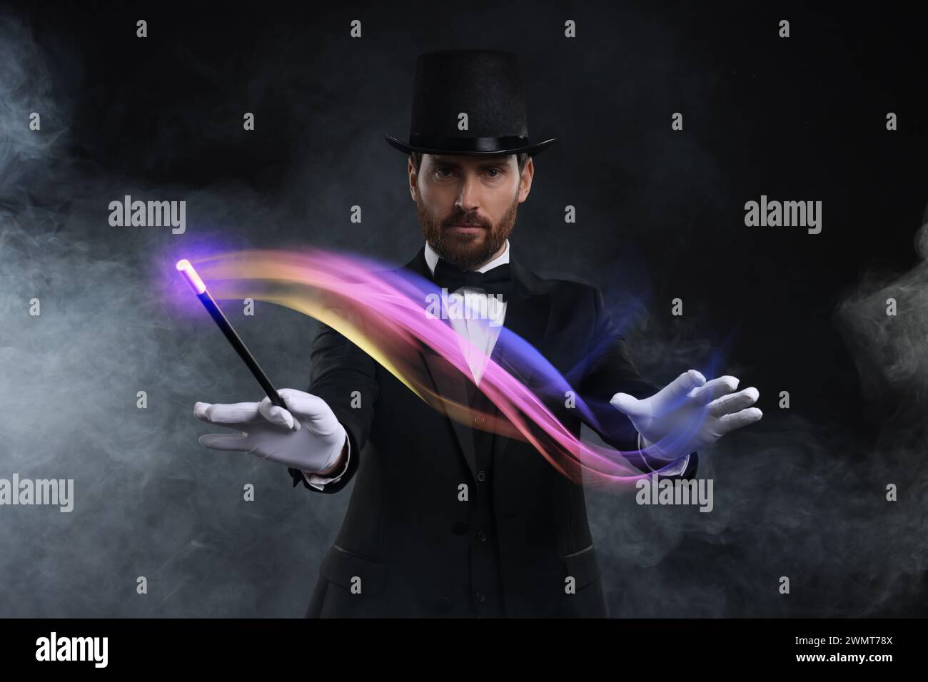 Magic and sorcery. Magician with wand and fantastic light in smoke on ...