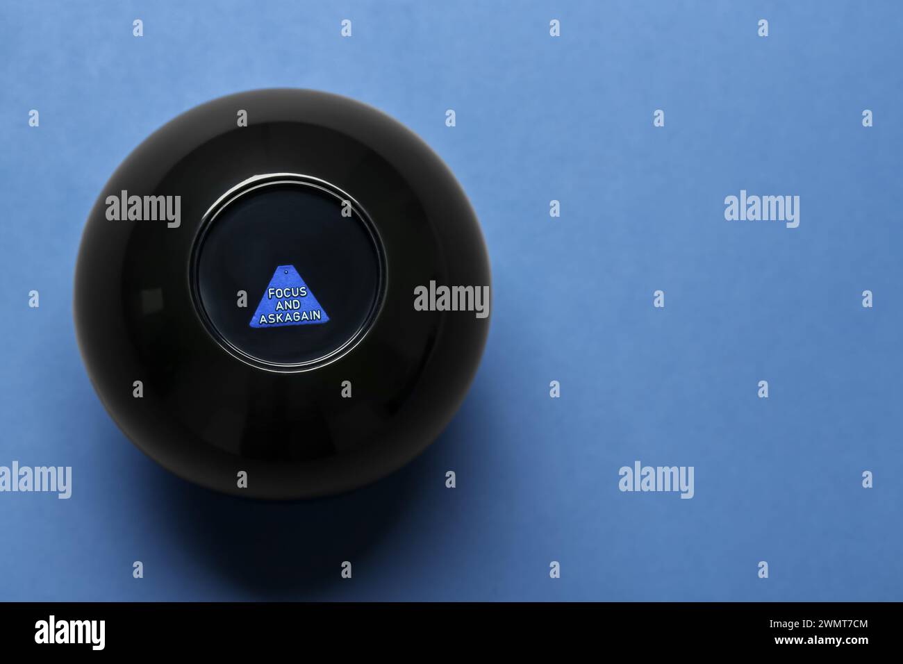 Magic eight ball with prediction Focus And Ask Again on blue background ...