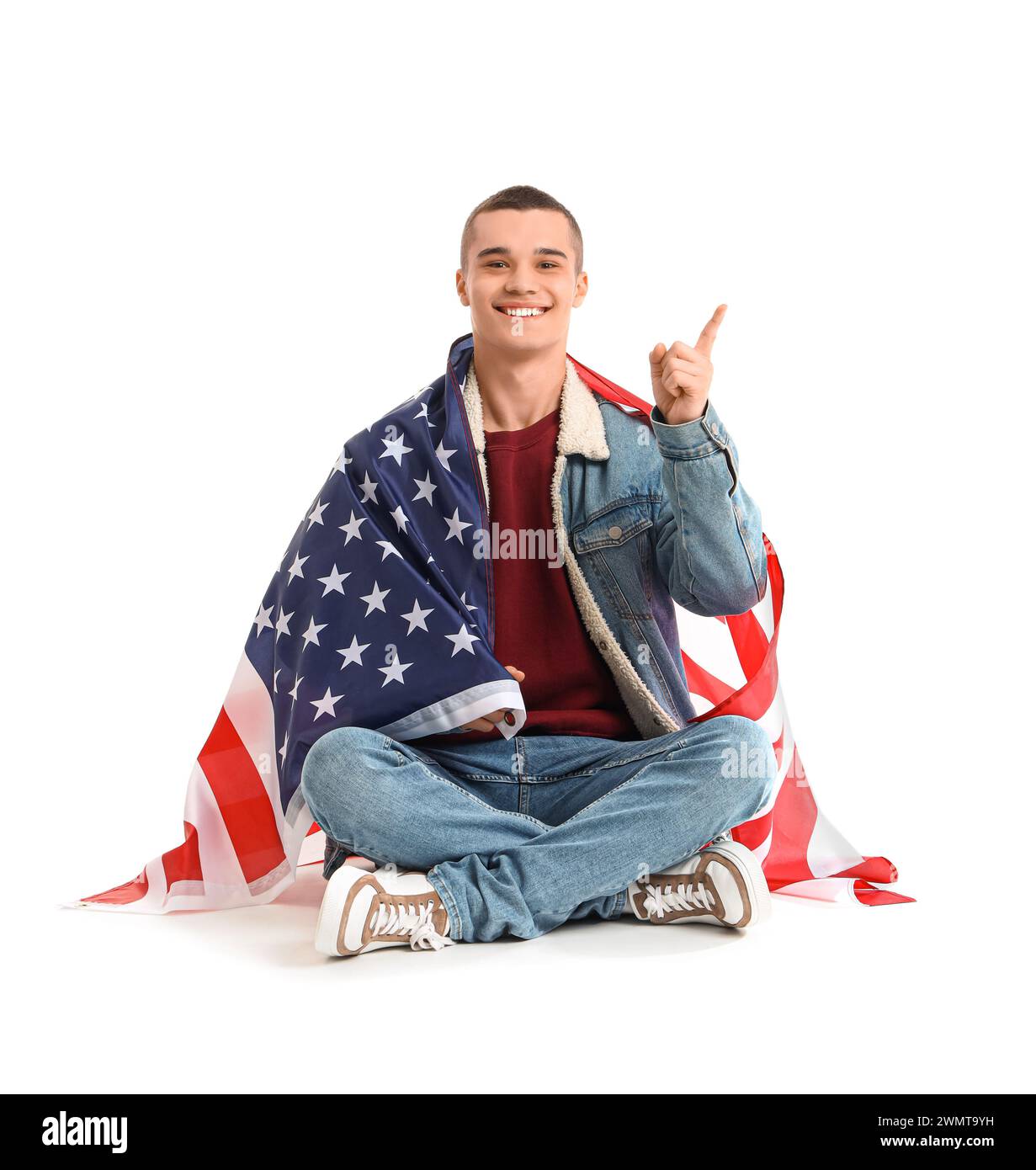 Teenage boy with USA flag pointing at something on white background ...