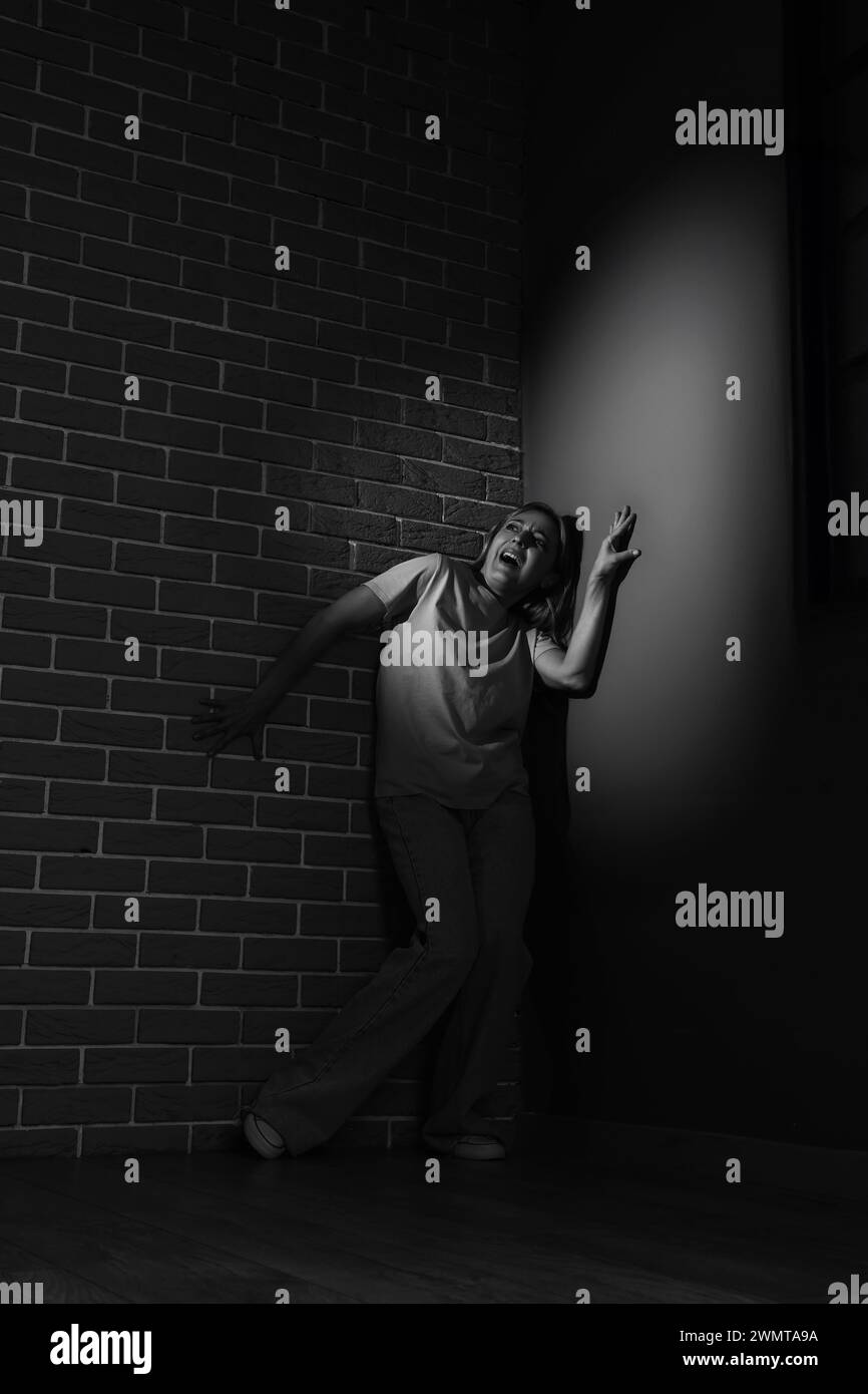 Scared mature woman in corner Stock Photo - Alamy