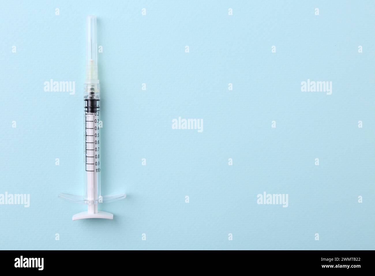 Cosmetology. Medical syringe on light blue background, top view. Space ...