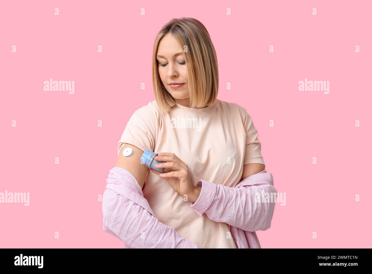 Woman with glucose sensor for measuring blood sugar level and ...