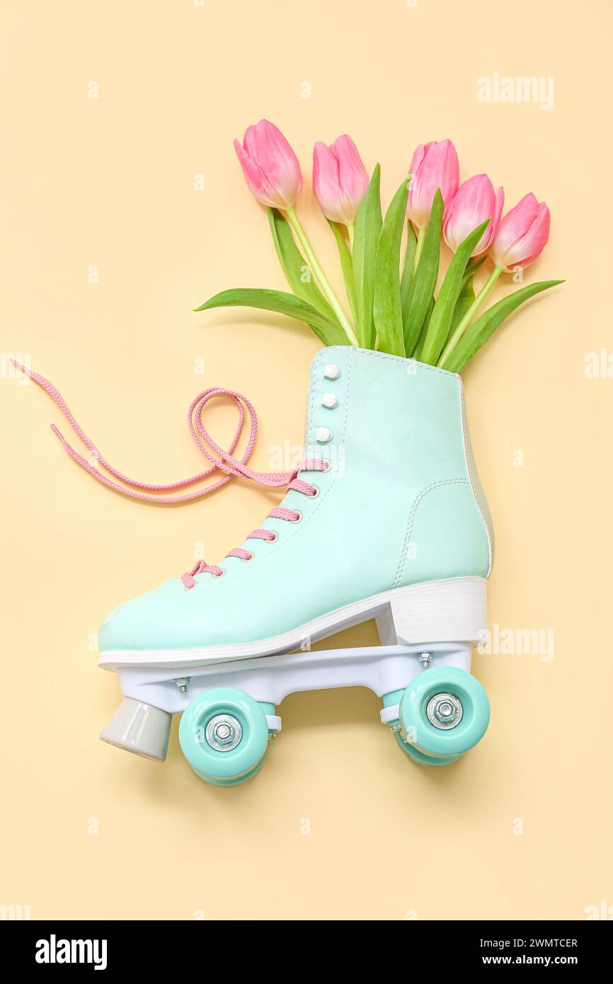 Composition with roller skate and tulip flowers on color background ...