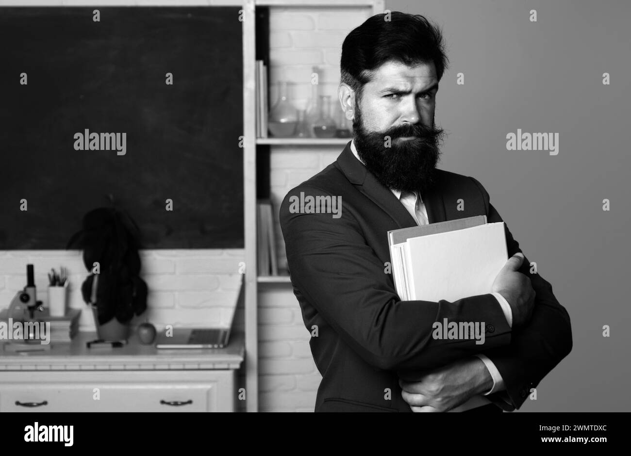 Confident middle-aged male teacher or professor standing in front of a ...