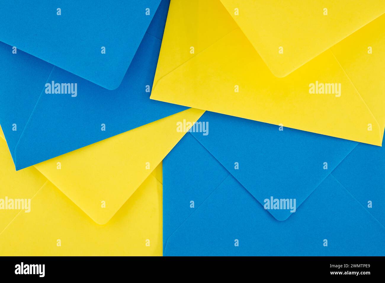 Blue and yellow paper envelopes organized in a symmetrical pattern ...