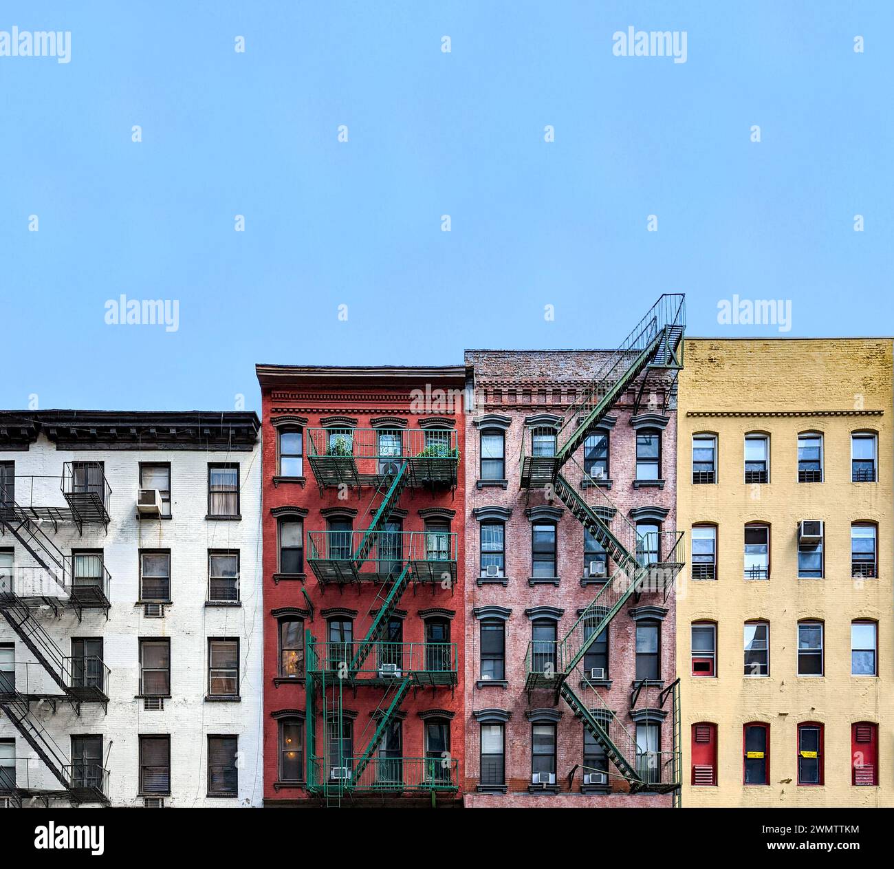Windows on colorful brick apartment buildings with empty blue sky ...