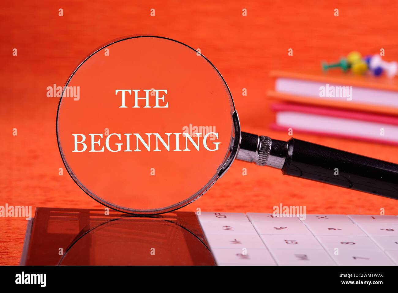 The beginning text written through a magnifying glass on an orange ...