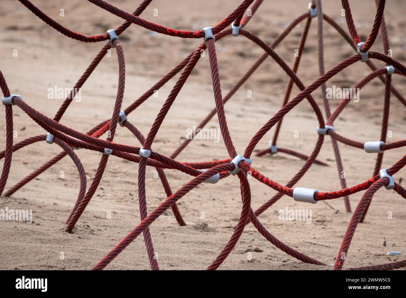 Red rope sections fastened with a metal clamp and a brown sand ...