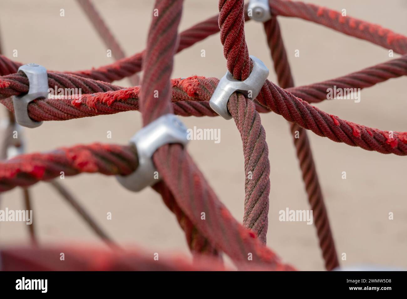 Red rope sections fastened with a metal clamp and a brown sand ...