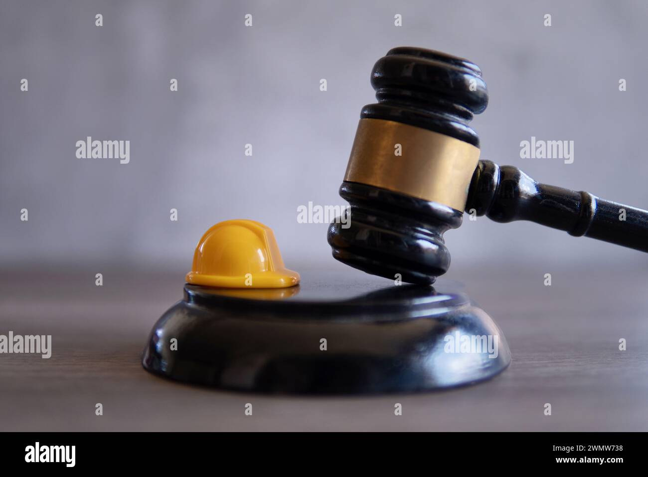 Closeup image of yellow hard hat and judge gavel. Labor law concept ...