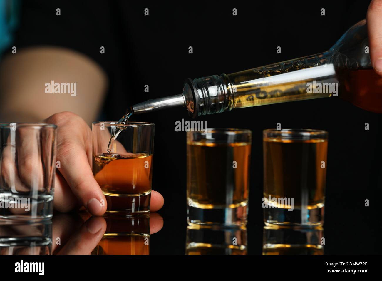 Bartender pouring alcohol drink into shot glass at mirror bar counter, closeup Stock Photo - Alamy