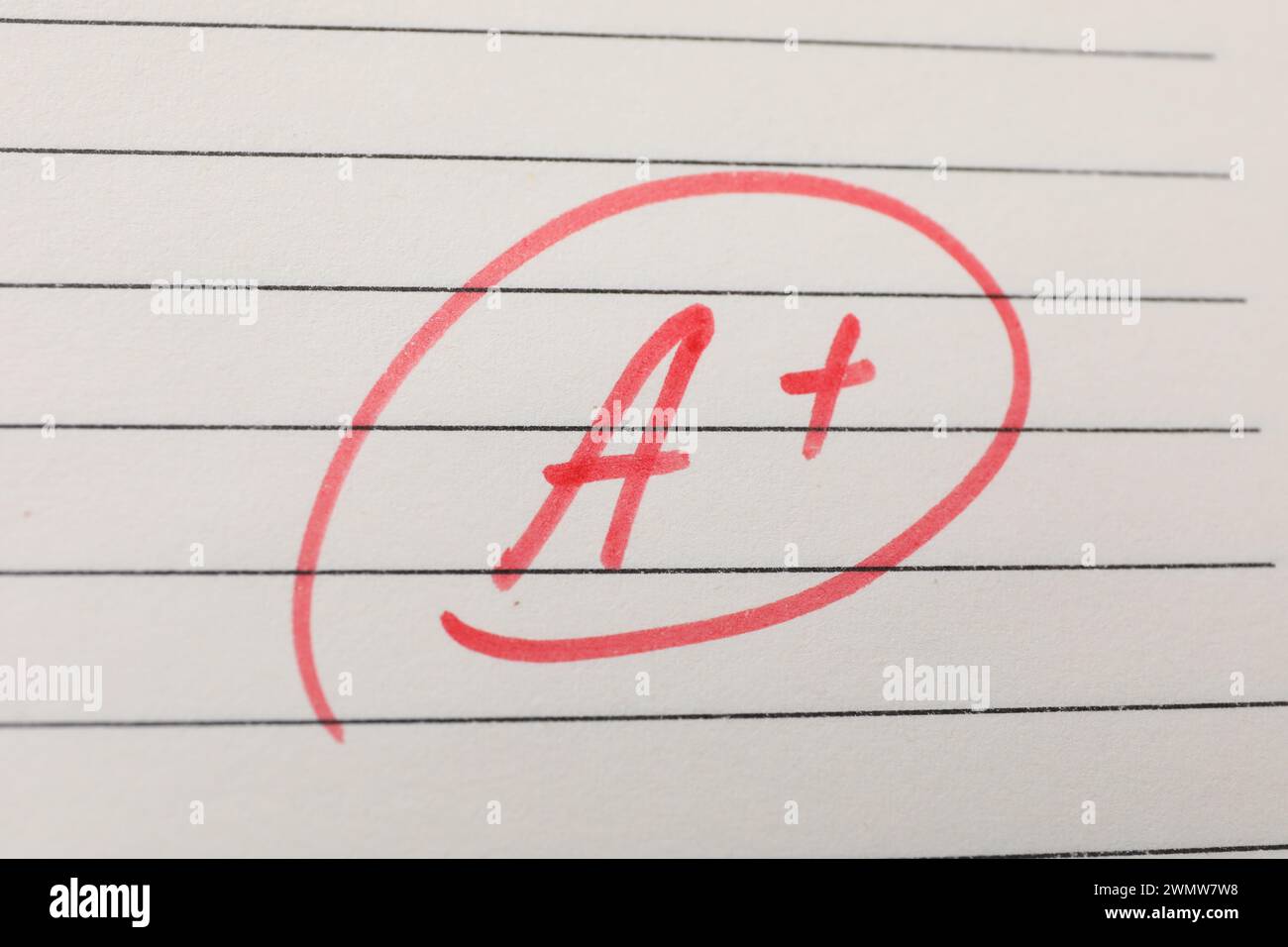 School grade. Red letter A with plus symbol on notebook paper, top view ...