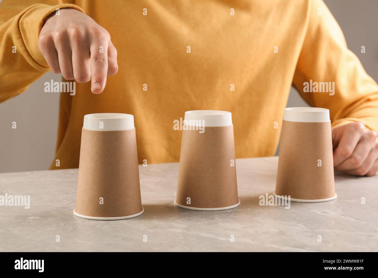 Man playing shell game at light marble table, closeup Stock Photo - Alamy