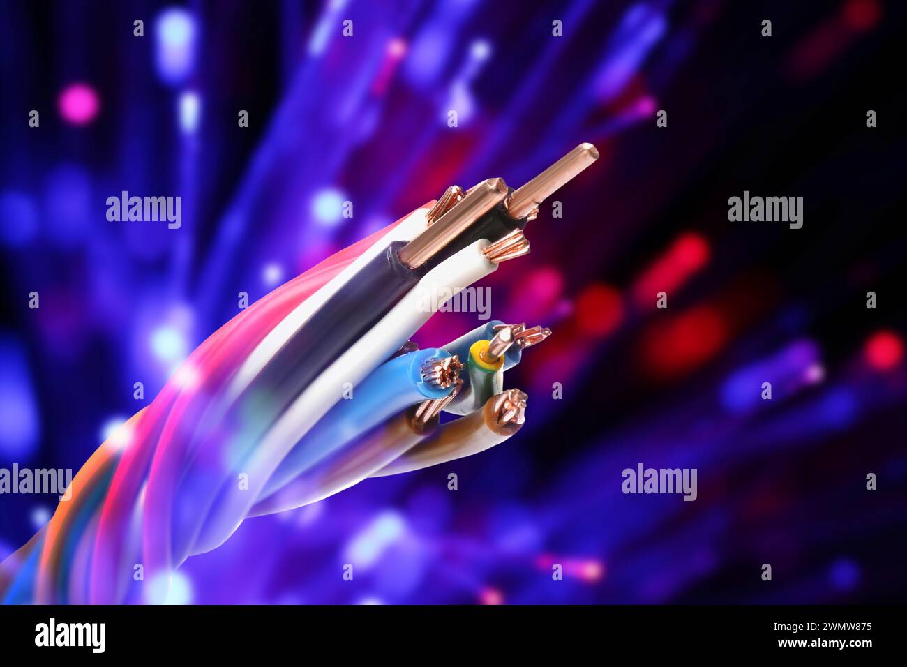Colorful electrical wires against dark background with blurred lights ...