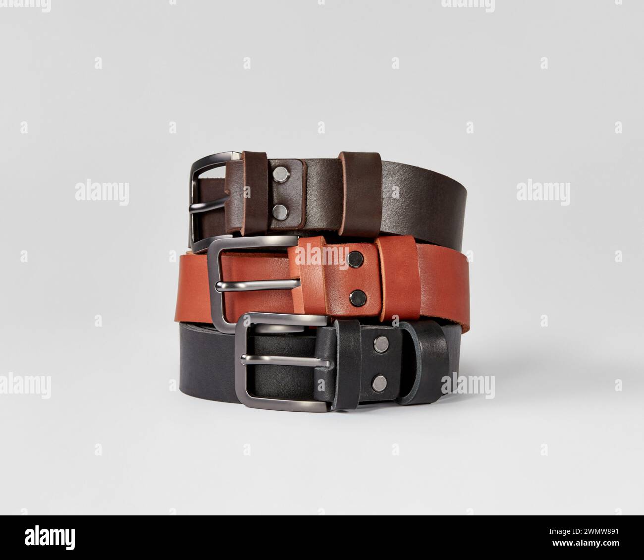 Three folded leather belts of different colors with DAD embossing Stock ...