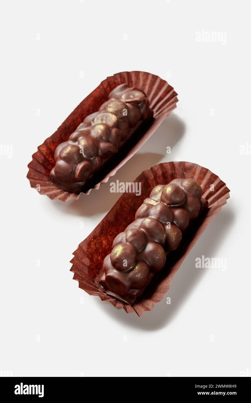Two dark chocolate bars with hazelnuts in paper wrappers Stock Photo ...