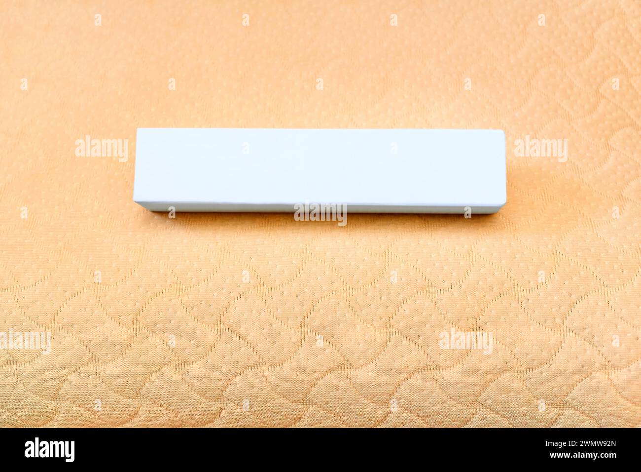 White oblong box on a peach fuzz fabric textile background pillow Stock ...