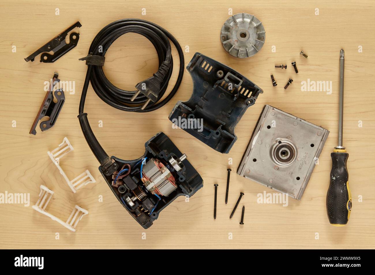 sanding machine being dismantled to be repaired using a screwdriver ...