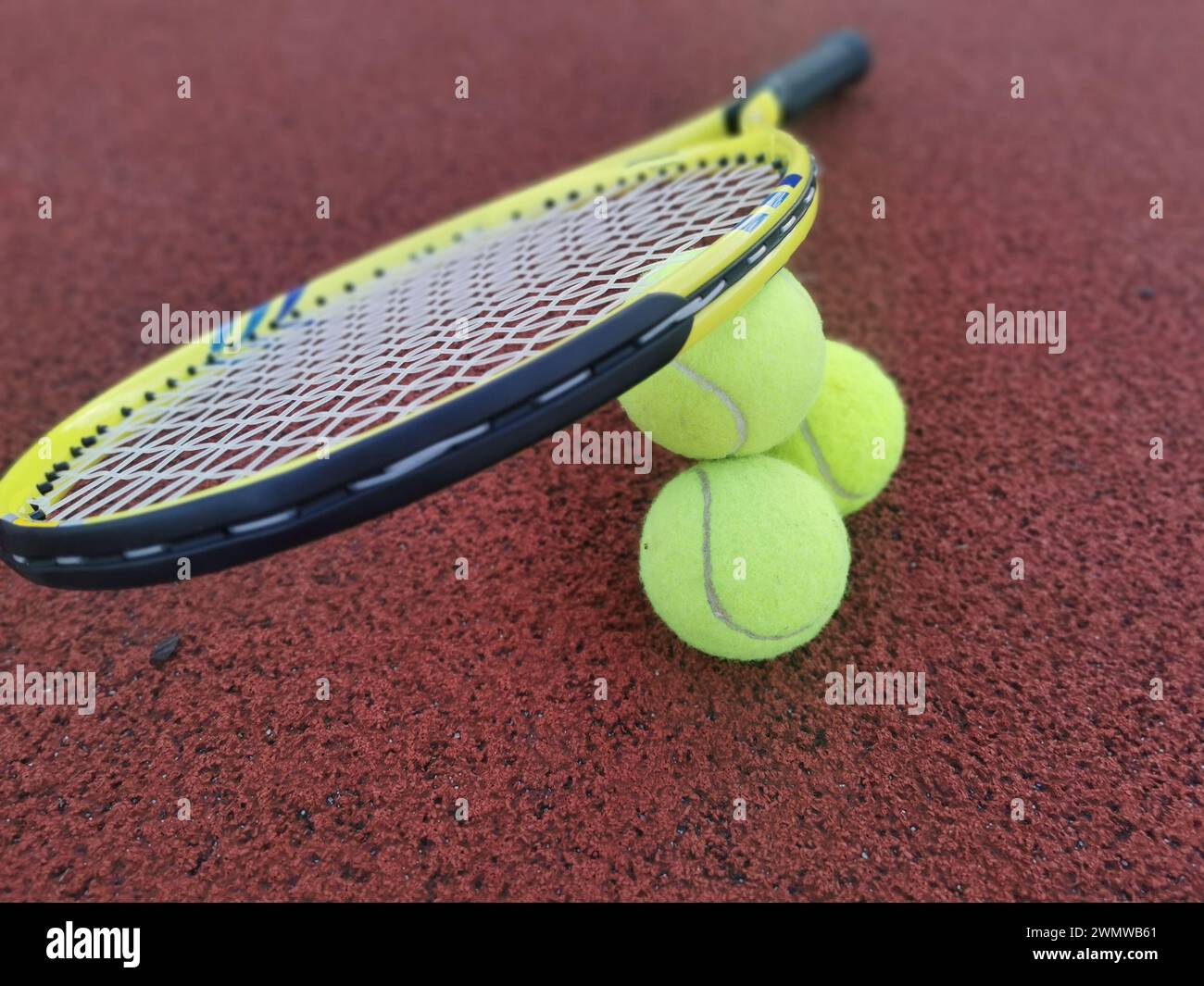 Tennis. Tennis ball and racket on a red background of tennis court with ...
