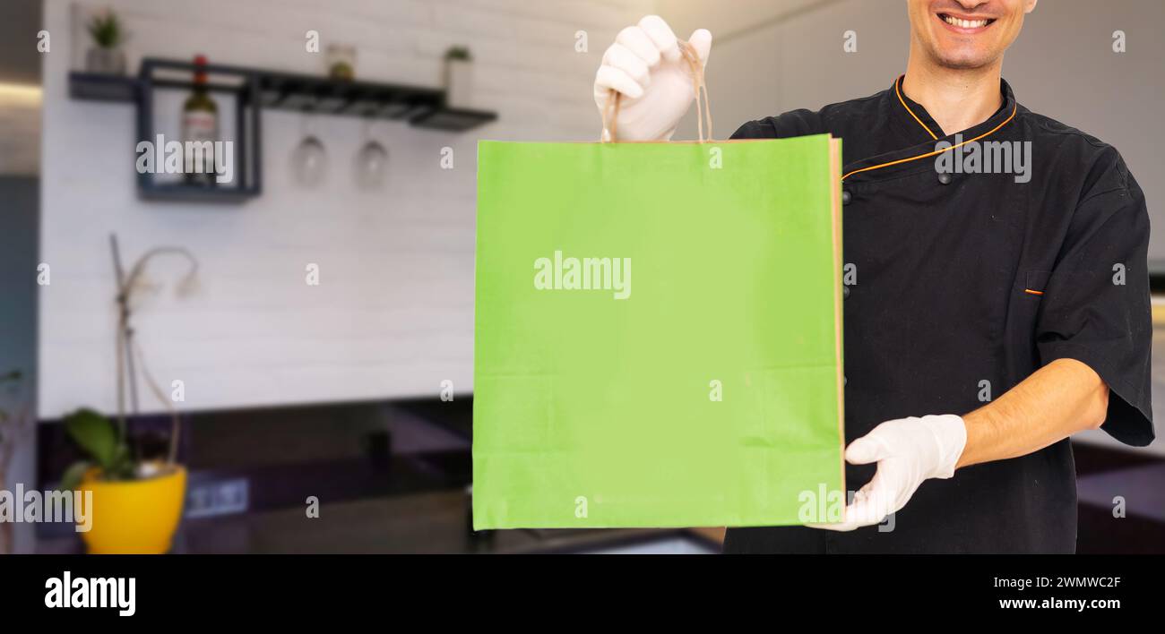 box with fast food being carried by delivery man in uniform for one of ...