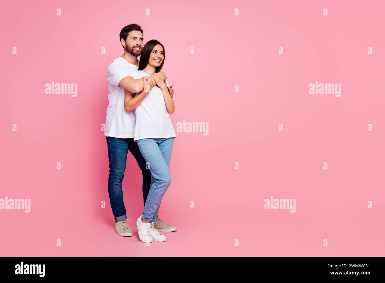Full length photo of lovely young couple hug look empty space promotion ...