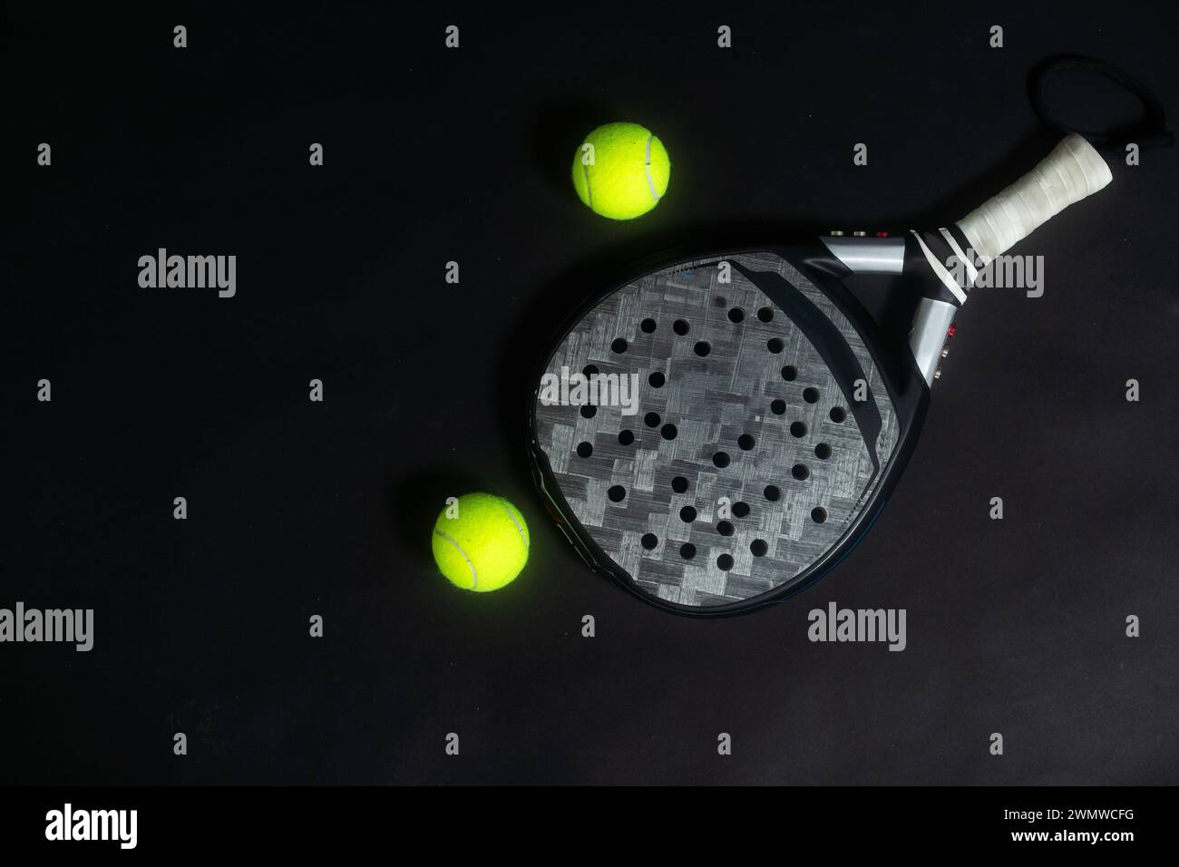 Detailed background of black and white padel racket and ball on black ...