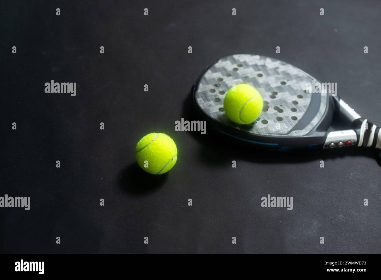 Detailed background of black and white padel racket and ball on black ...