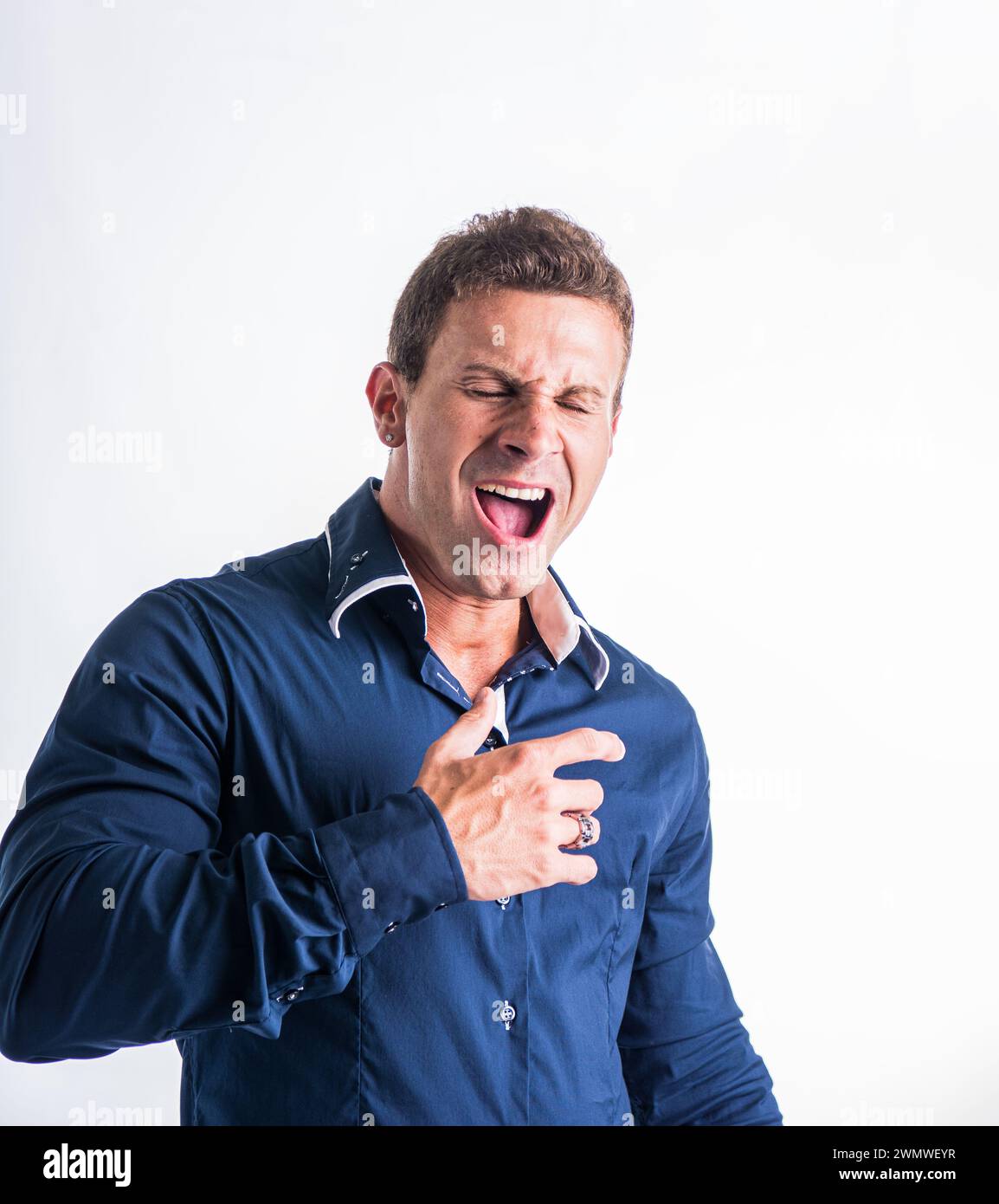 A man contorting his face humorously with his hands, creating a comical ...