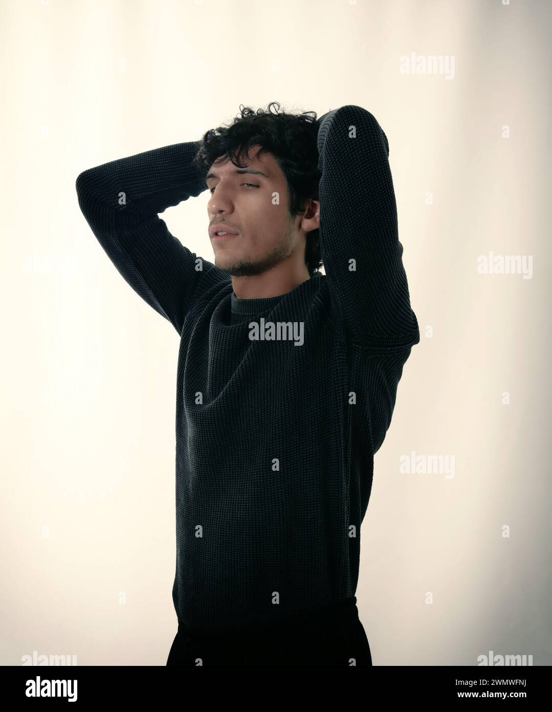 A man is seen with his hands resting behind his head in a relaxed ...