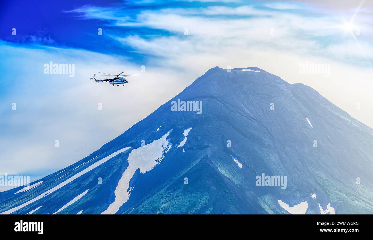 The Helicopter flying over Ilyinsky Volcano and Kurile lake on sunlight ...