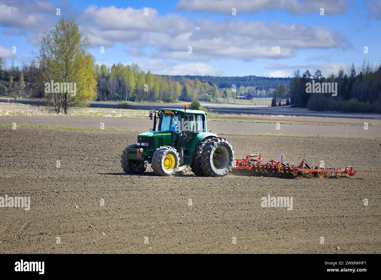 Farmer working in field with John Deere 6320 tractor and Vaderstad NZ ...