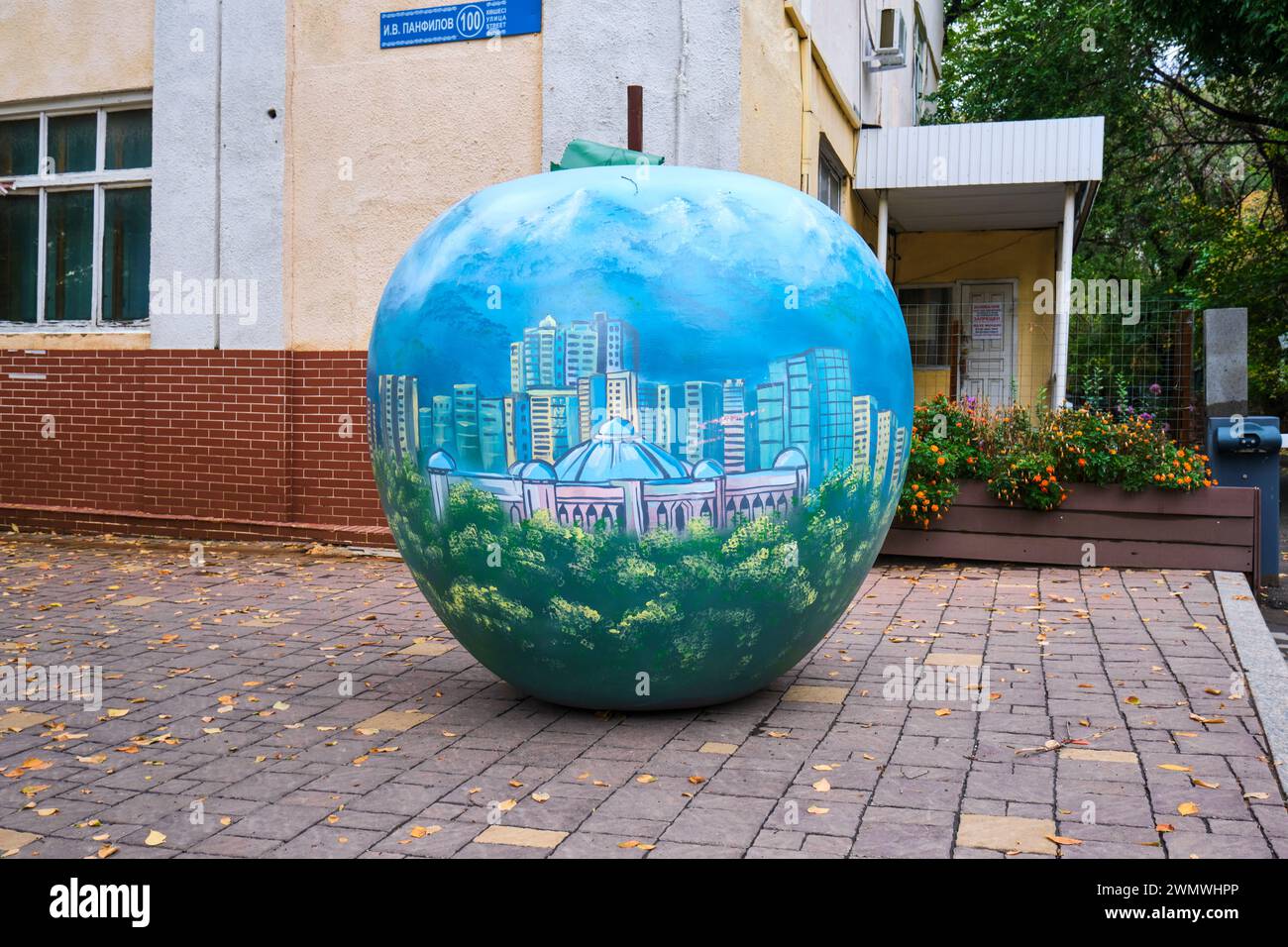 A large, giant painted apple with a famous location of the city, a ...