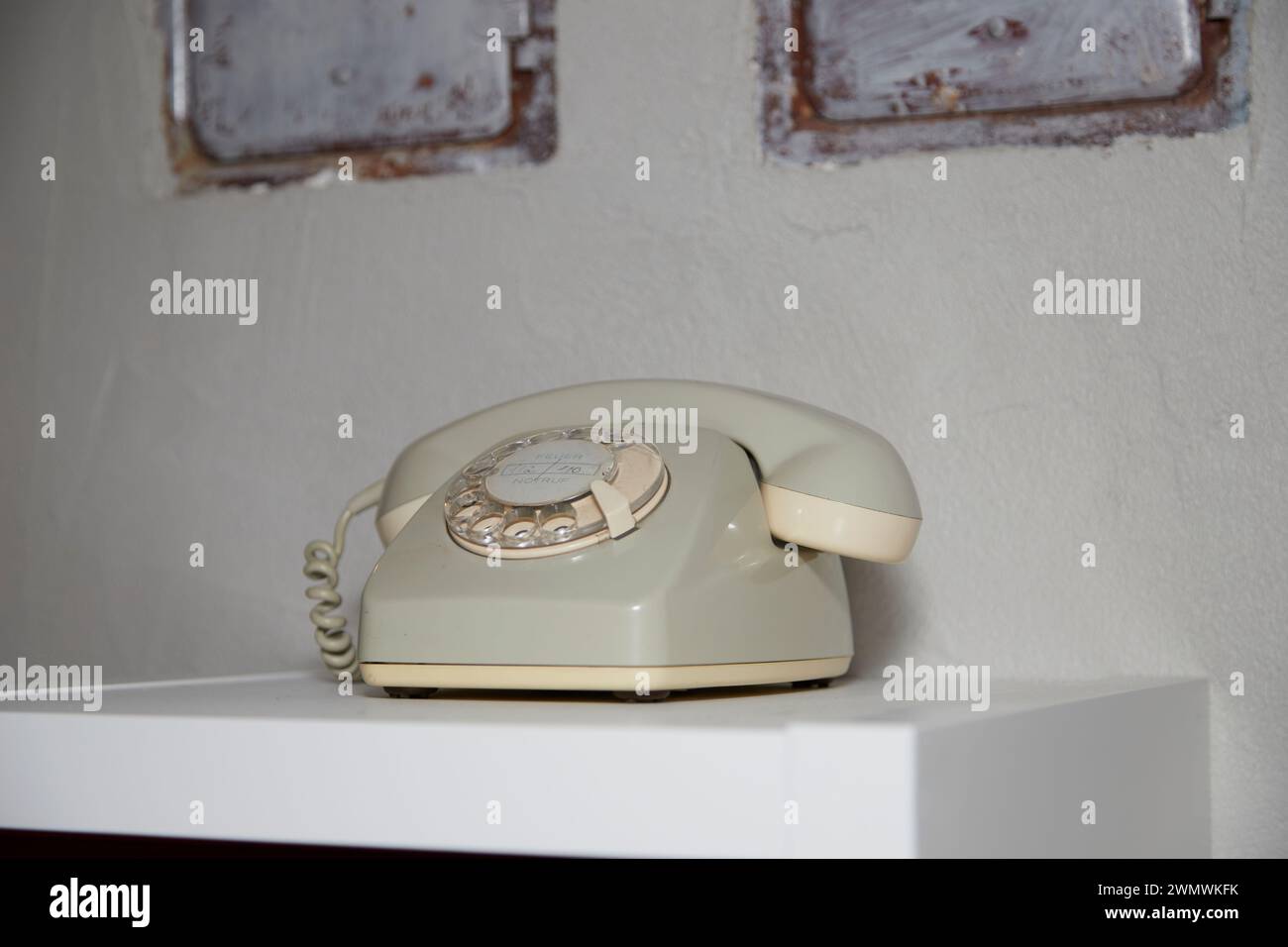 old telephone with a separate receiver and rotary dial on a board in ...