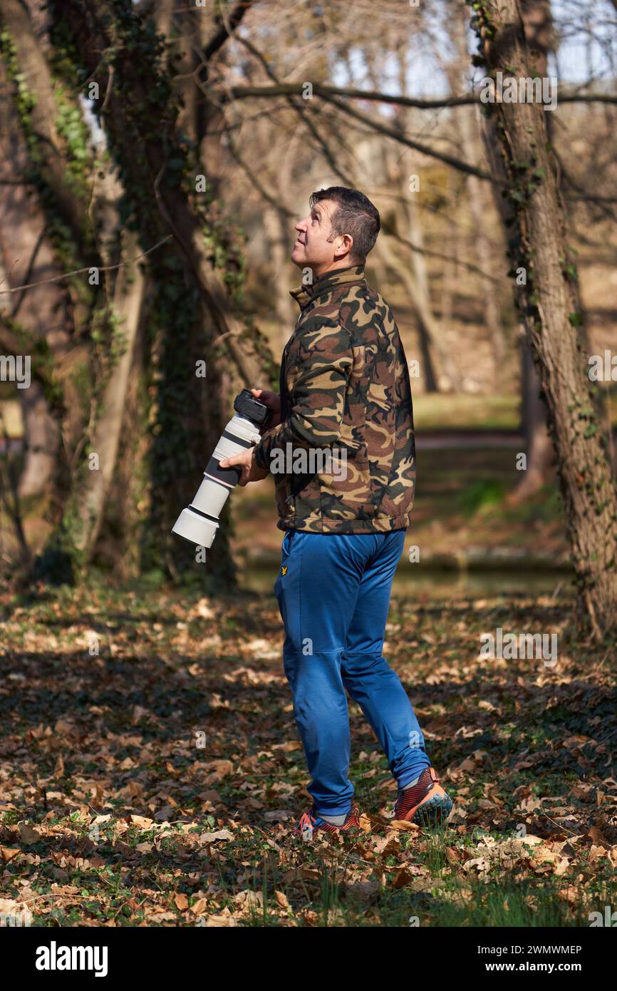 Wildlife and nature photographer in the forest, with camera and long ...