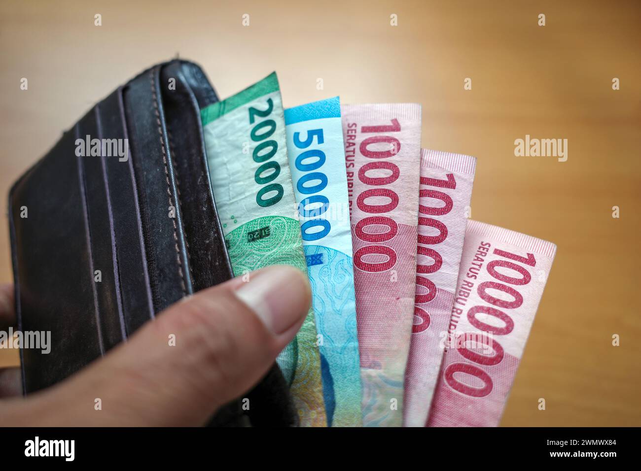 An Asian people take Indonesian money, rupiah from wallet. Saving and ...