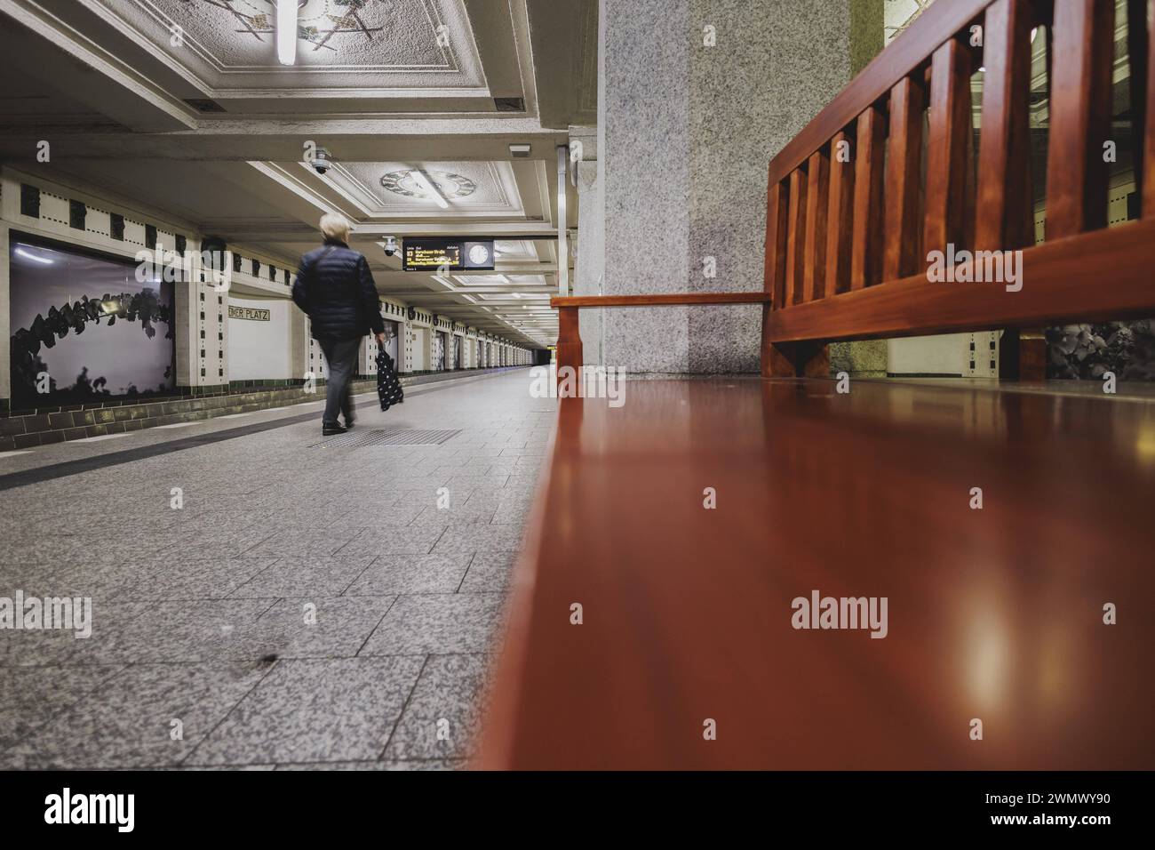 Eine Frau laeuft entlang des leeren Bahnsteigs der U-Bahnlinie 3 auf ...