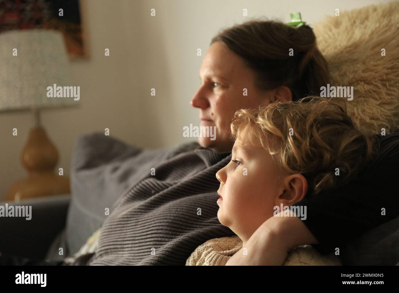 Mother and son portrait in a residential house with contrast light from ...