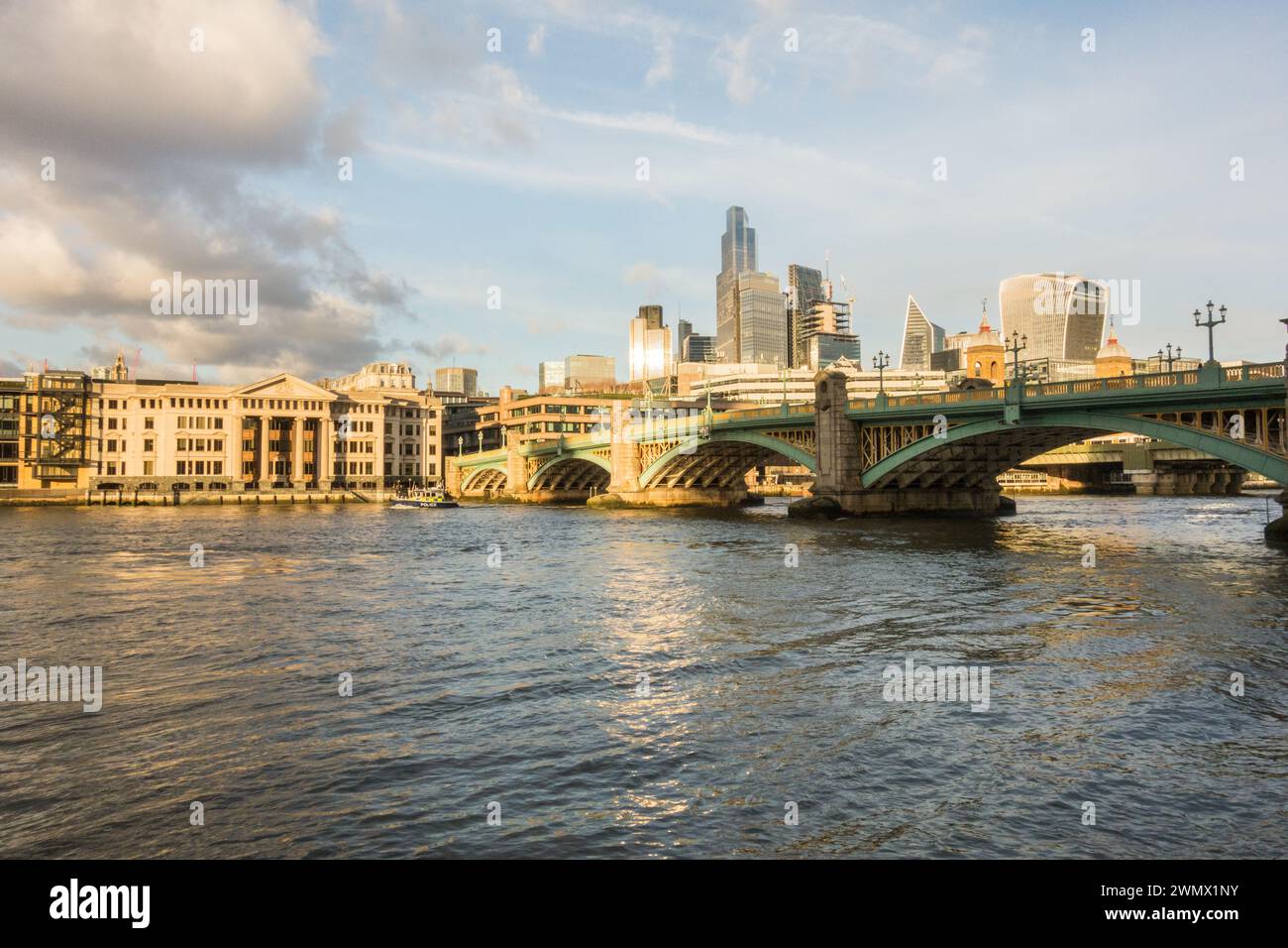 A police cruiser passing under Southwark Bridge on the River Thames ...