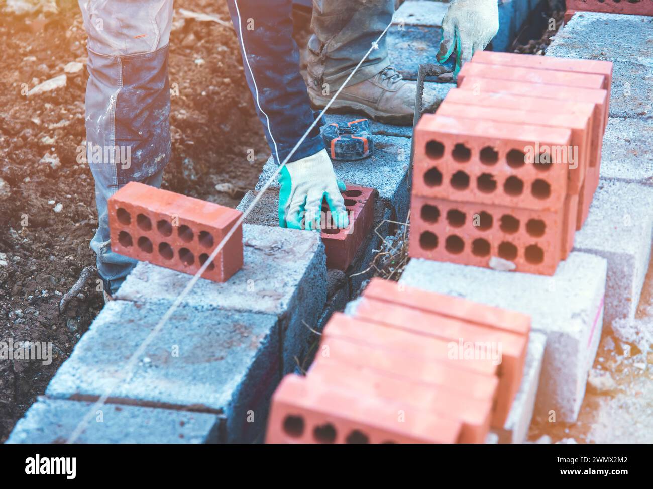 Hard working bricklayer laying concrete blocks on top of concrete ...