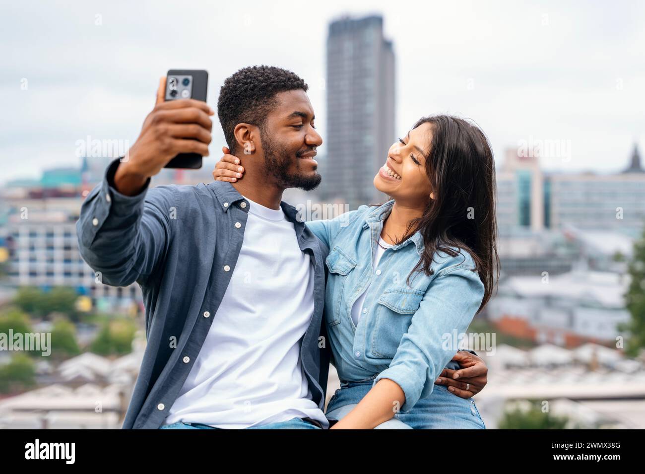 A handsome man and a beautiful woman sitting back to back on the ...
