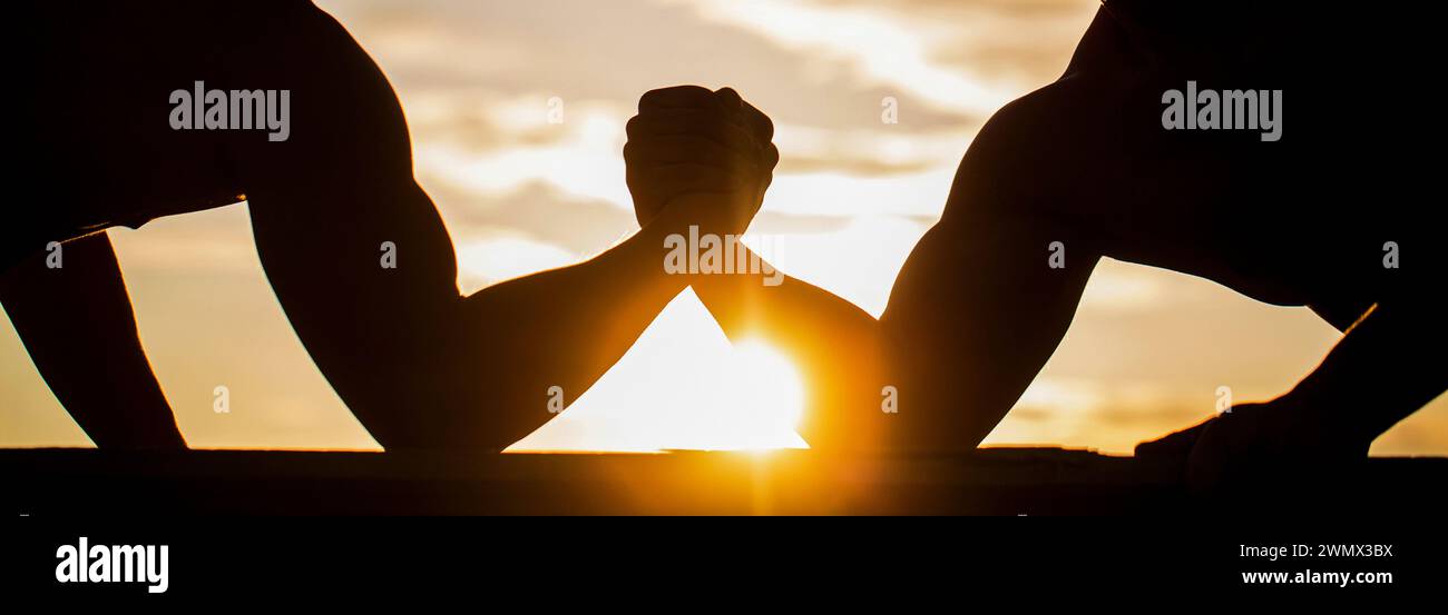 Rivalry, closeup of male arm wrestling. Sunset, sunrise. Men measuring ...