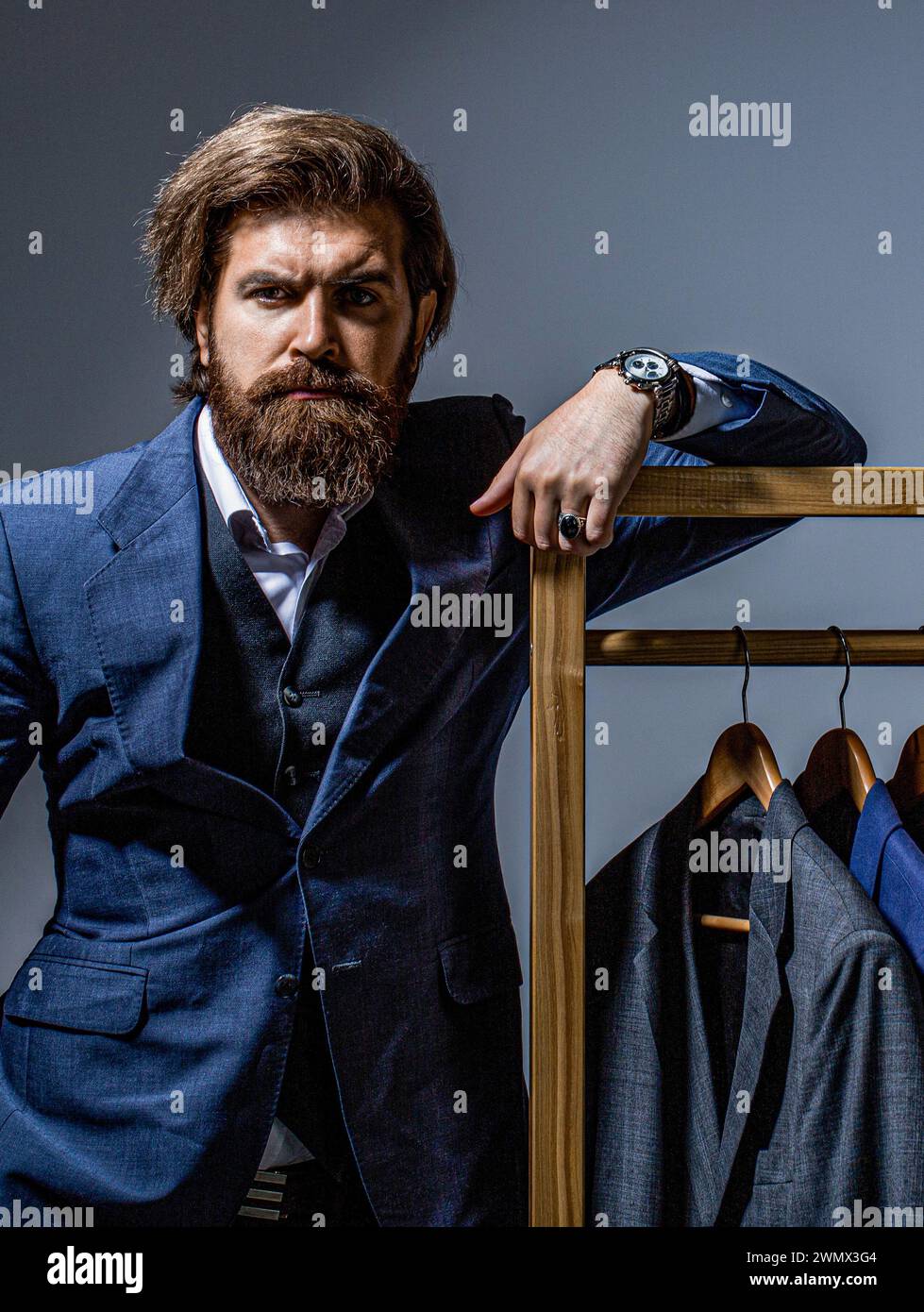 Tailor, tailoring. Stylish men's suit. Male suits hanging in a row ...