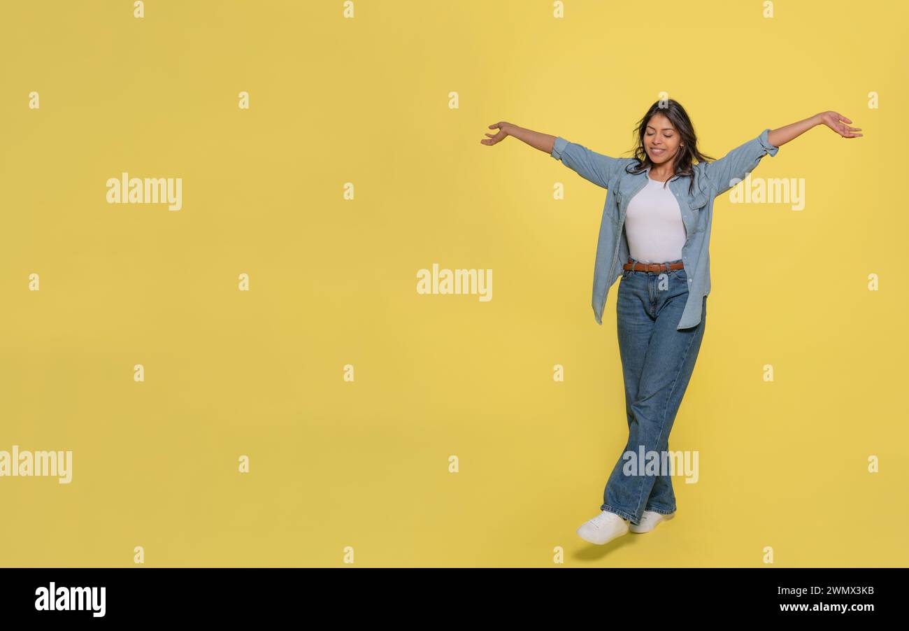 Joyful cheerful smiling attractive young brunette Indian woman in jeans ...