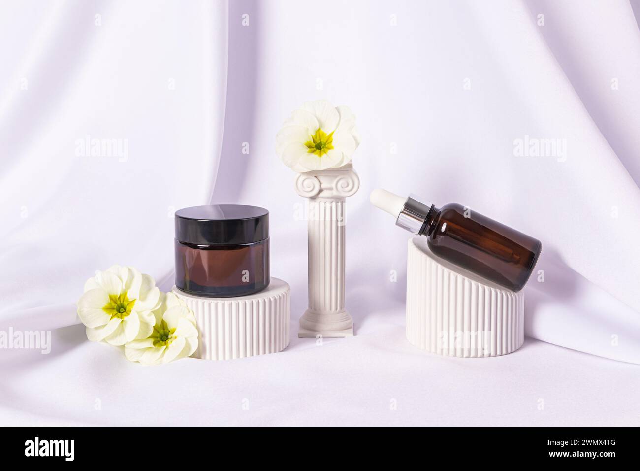 A moisturizing cosmetic product in amber glass bottles on white ...